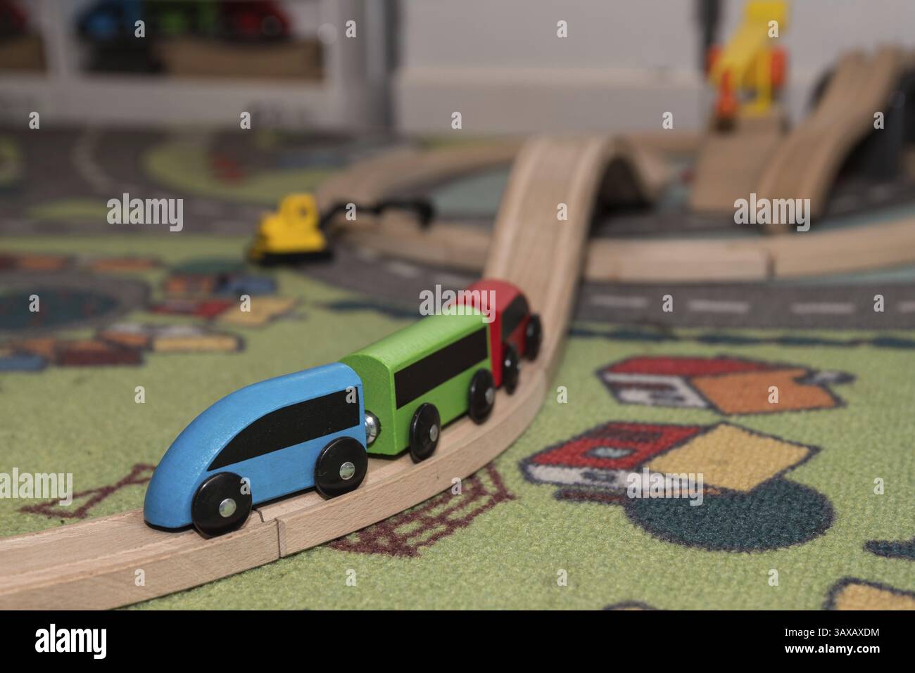 Colourful wooden toy train with tracks and toy carpet Stock Photo - Alamy