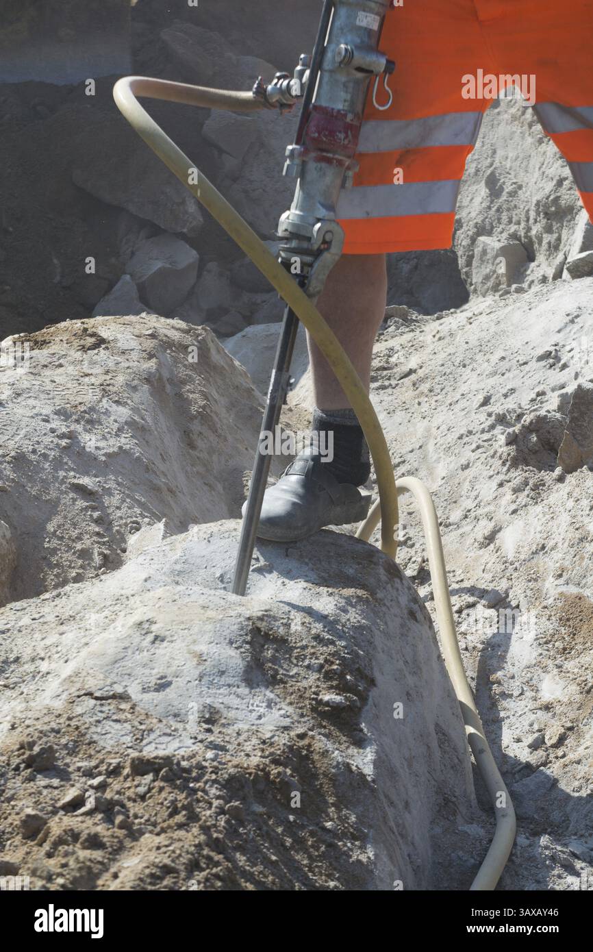 Construction worker working on stone with chisel hammer, Austria ...