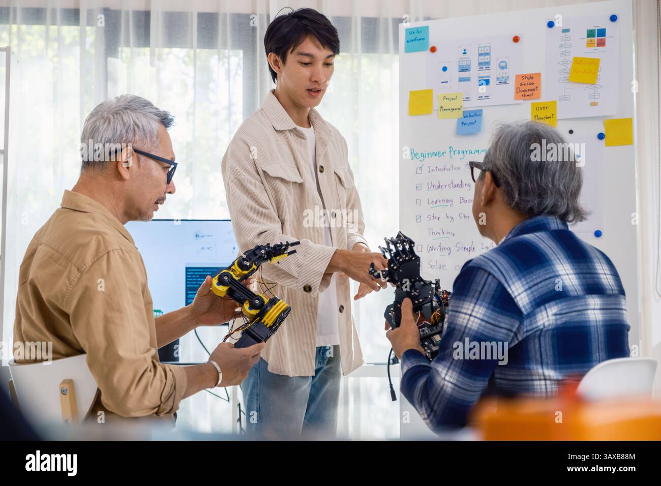 asian Robot arm engineers brainstorming in workshop to develop control technology with teamwork ...