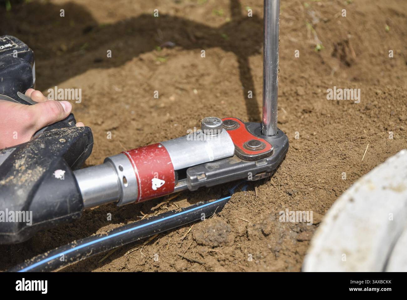 Skilled worker on construction site with press machine for laser ...