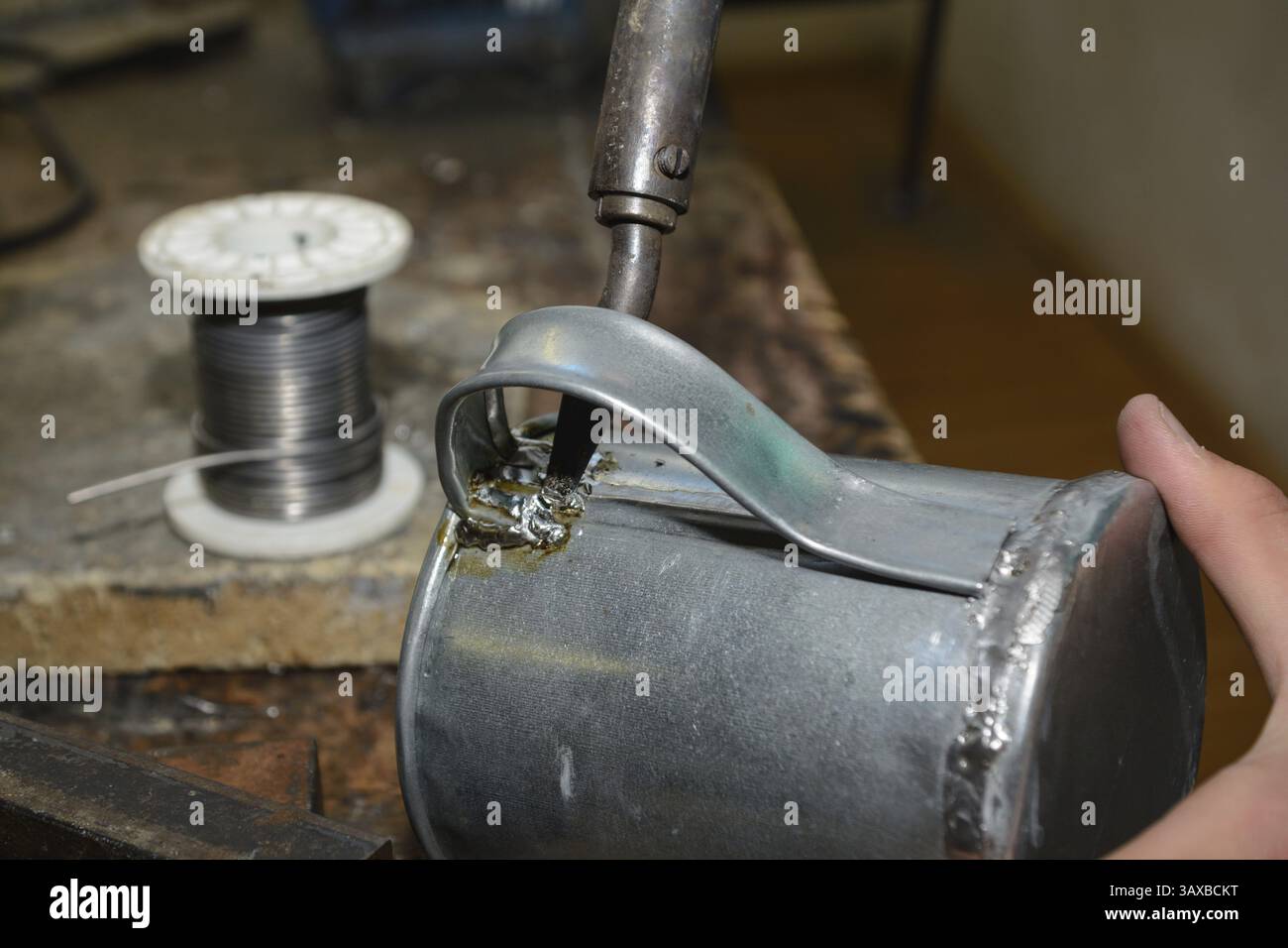 Craftsman learning to solder on a tin can - close-up Stock Photo - Alamy
