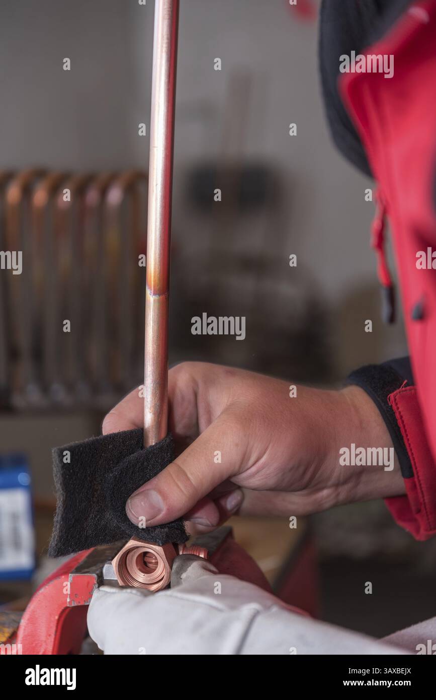 Craftsman works on soldered joints on copper parts - close-up ...