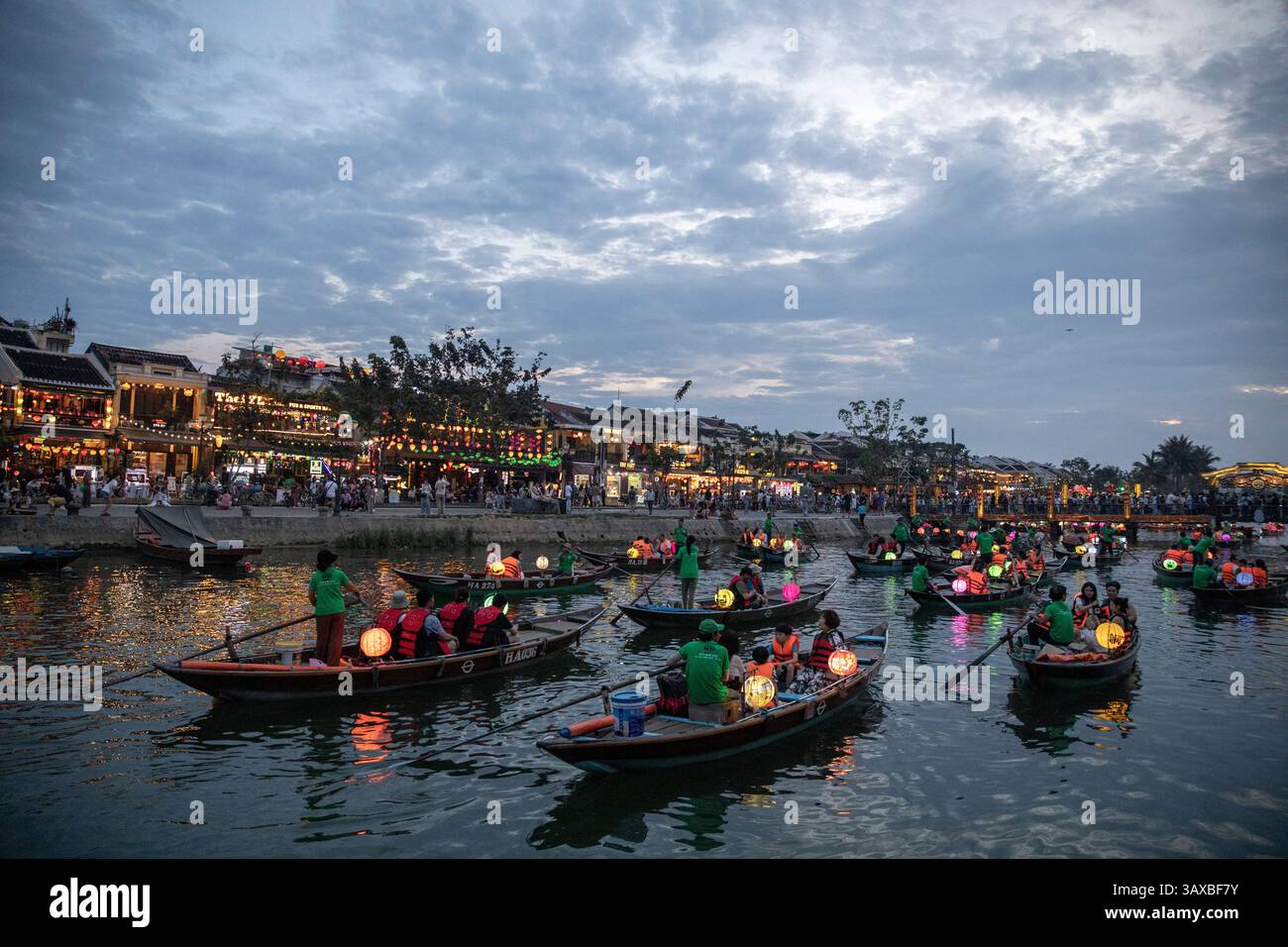 Tourism in Hoi An, Vietnam Visitors ride traditional lantern boats ...