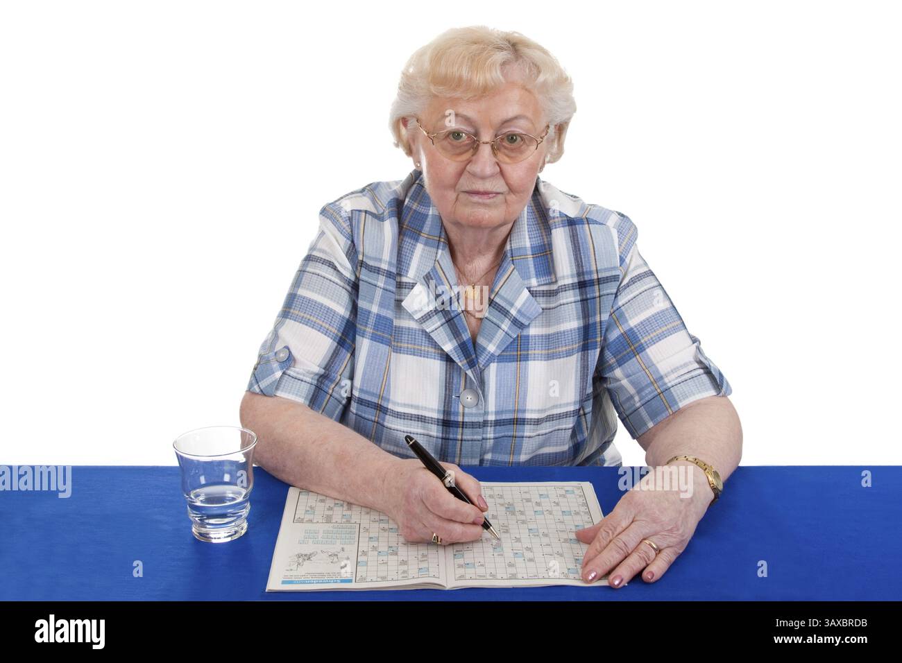 Old woman solving a crossword puzzle - isolated Elderly woman solving a ...