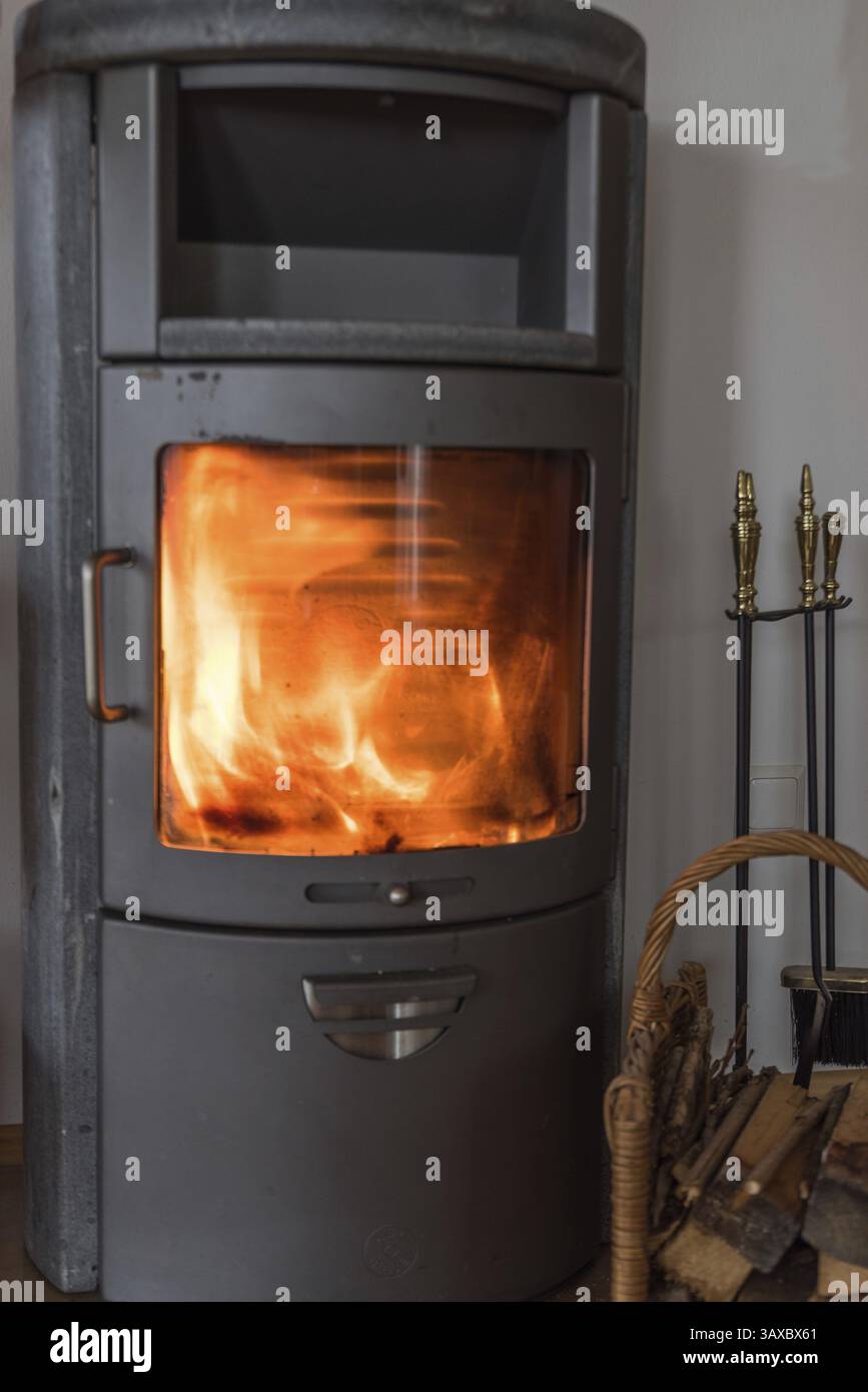 Warming fire with firewood in the viewing window of the nostalgic wood ...