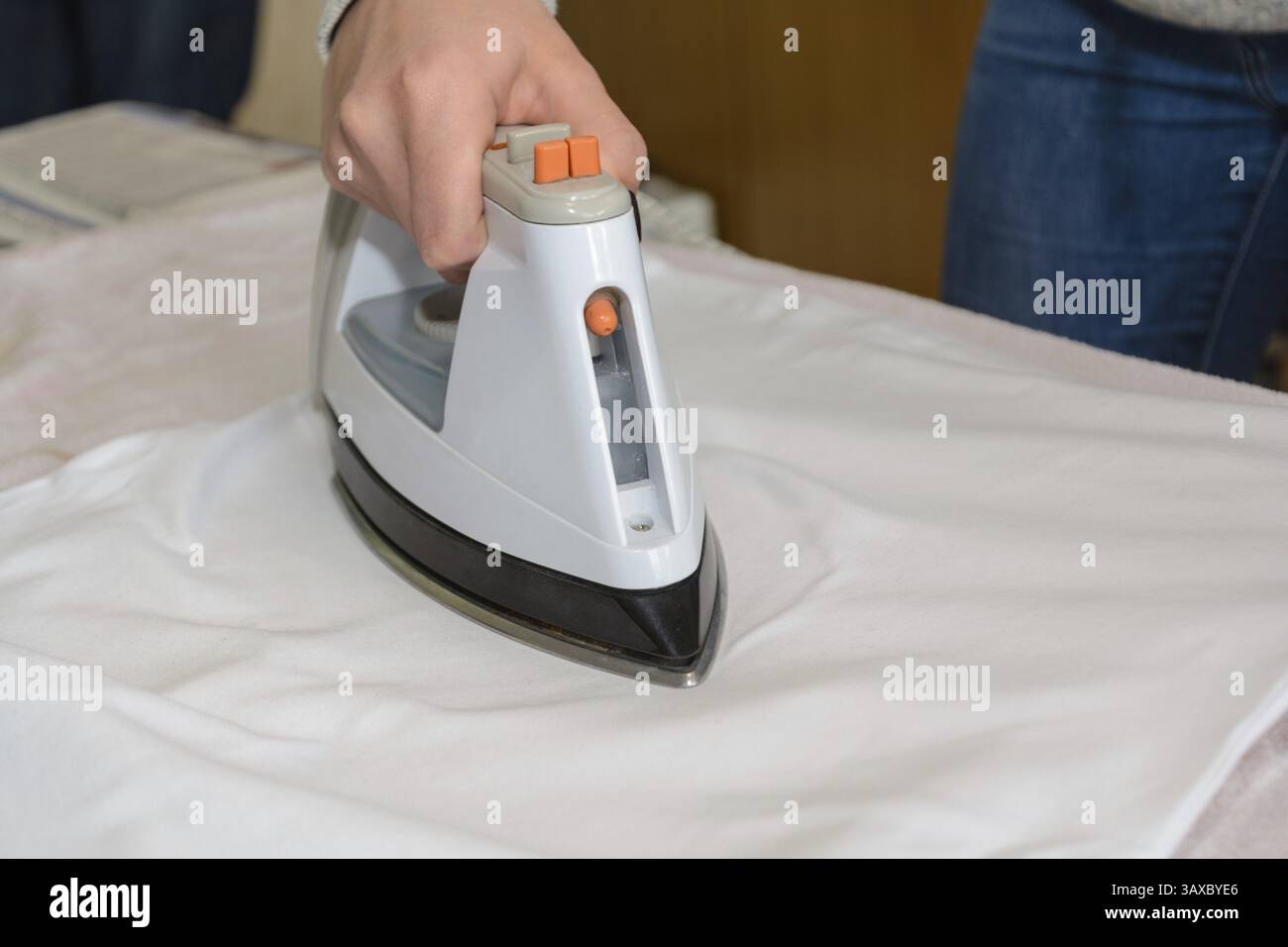 Ironing laundry on the ironing board with a steam iron Stock Photo - Alamy