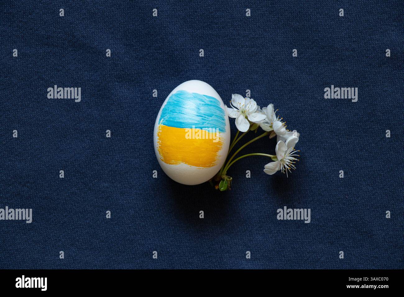 Easter egg painted in the colors of the Ukrainian flag and a branch of ...