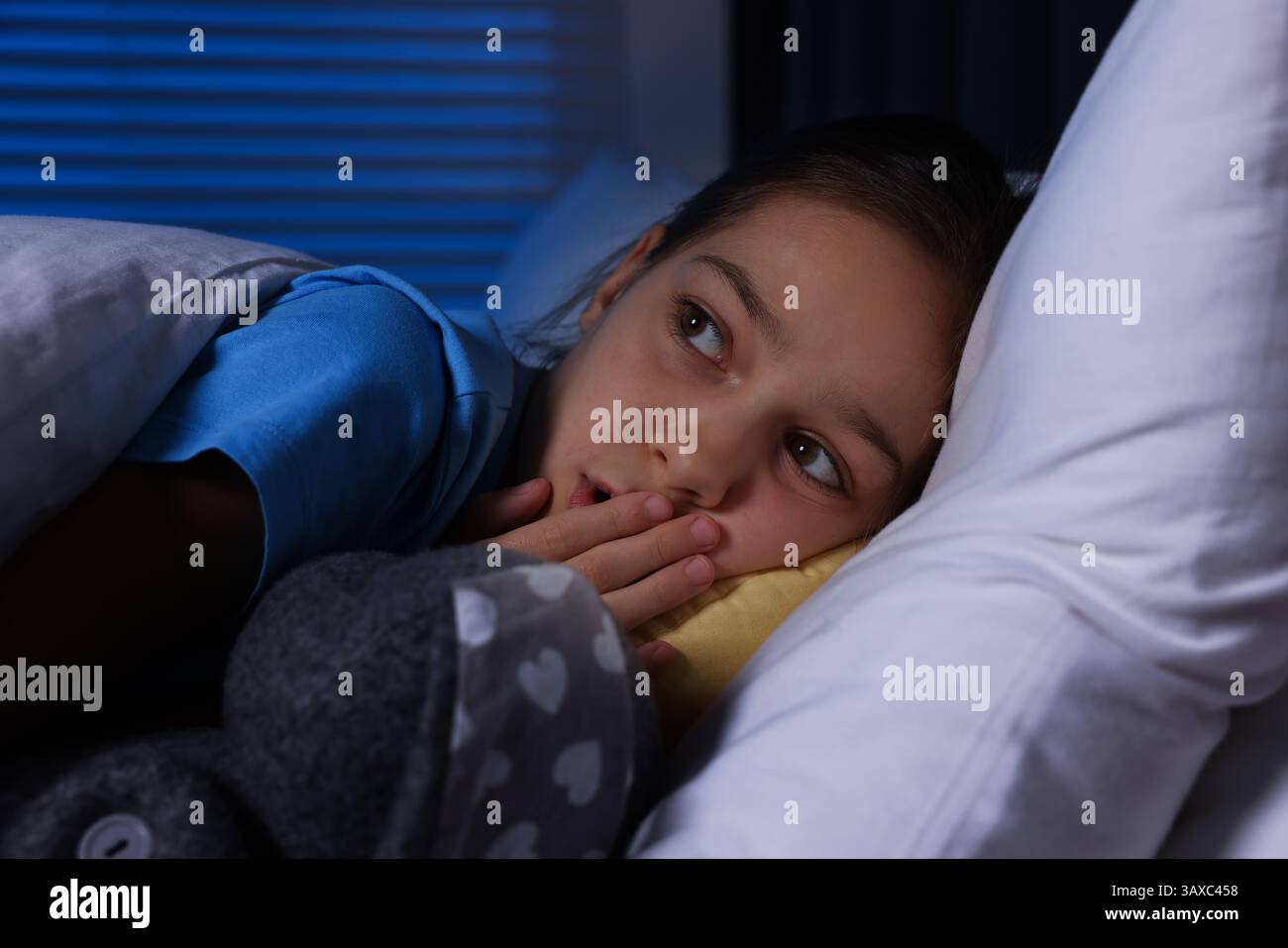 Afraid girl with toy in bed at night Stock Photo - Alamy