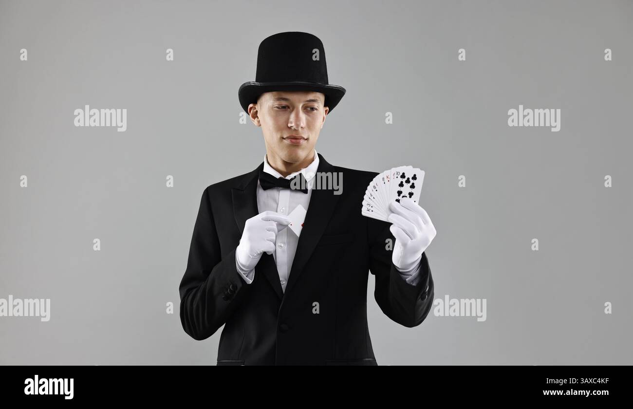 Illusionist hiding one playing card behind jacket lapel while showing ...
