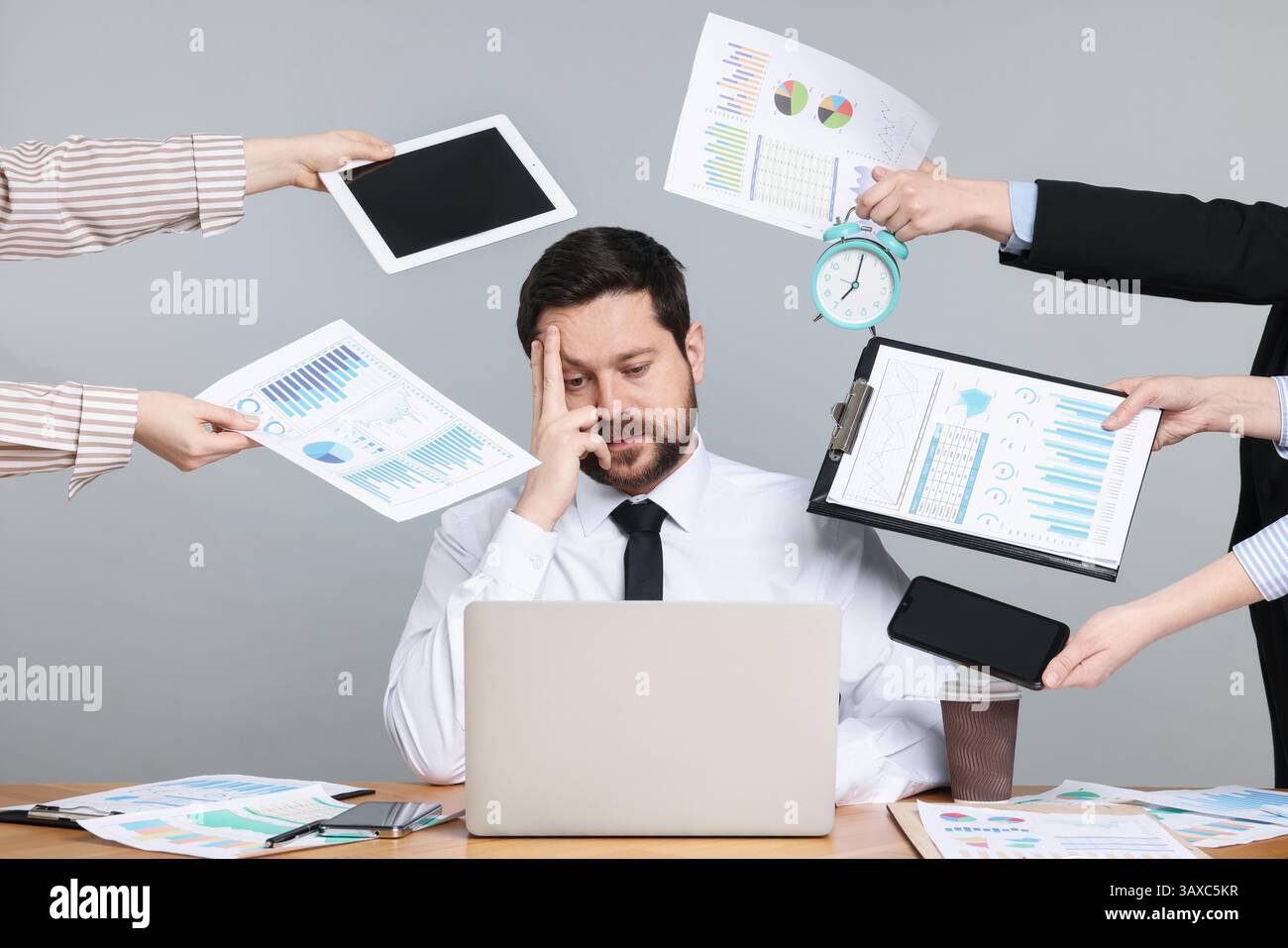 Man overwhelmed by different requests from colleagues at desk on light ...