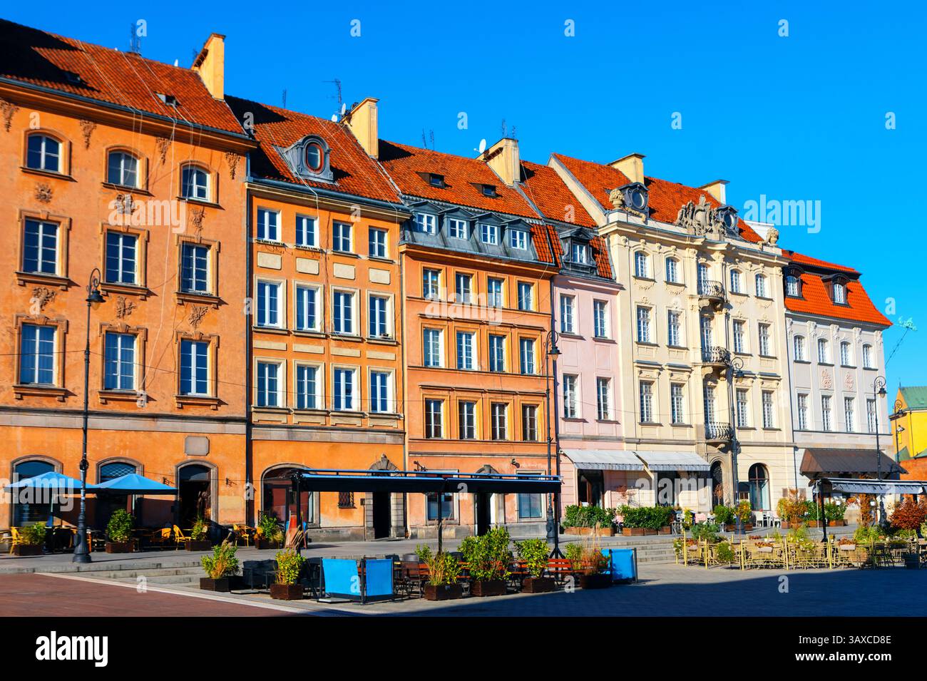 Colorful historic buildings line a sunny square in Warsaw Old Town ...