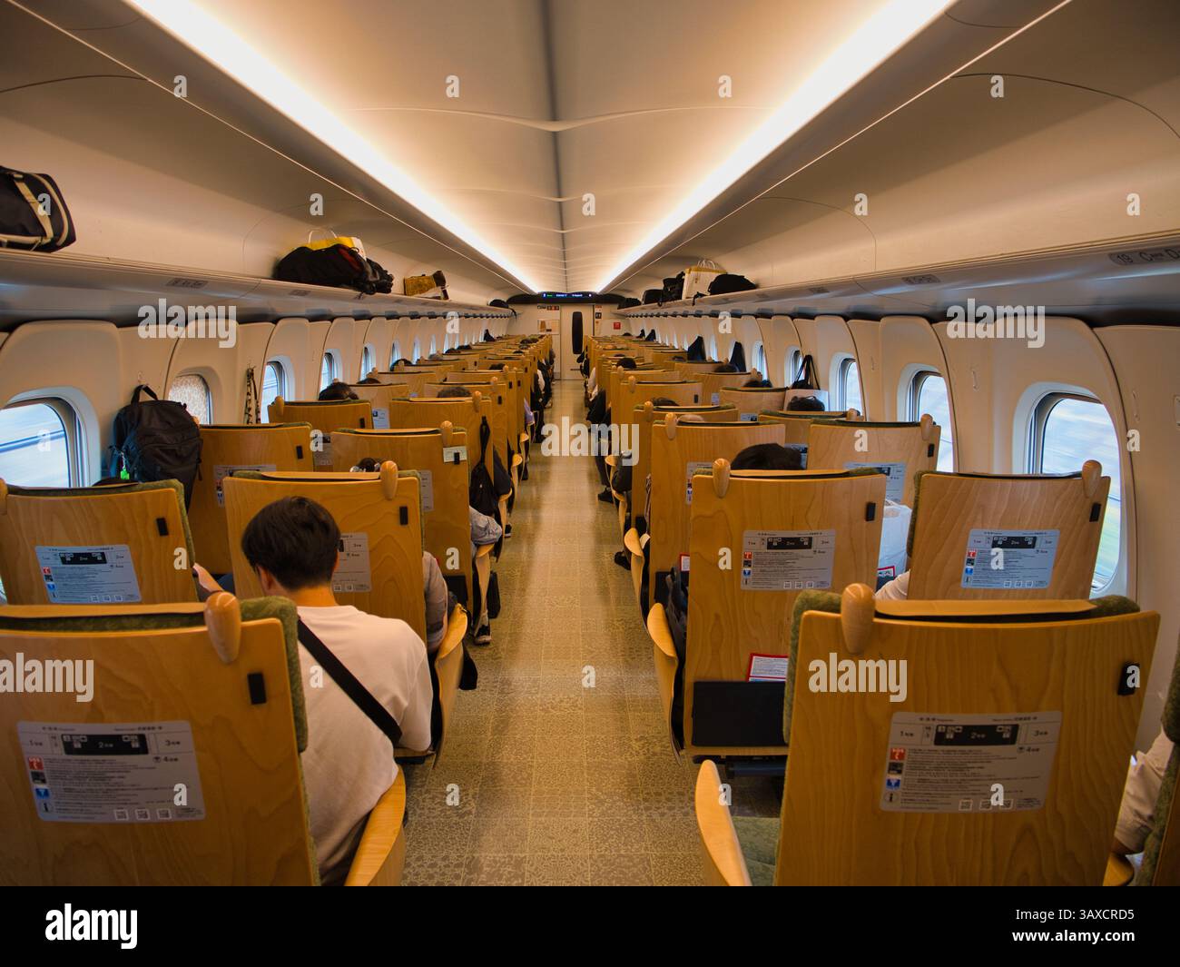 Interior of a shinkansen high-speed train on Kyushu Island, Japan, showing passengers seated in ...
