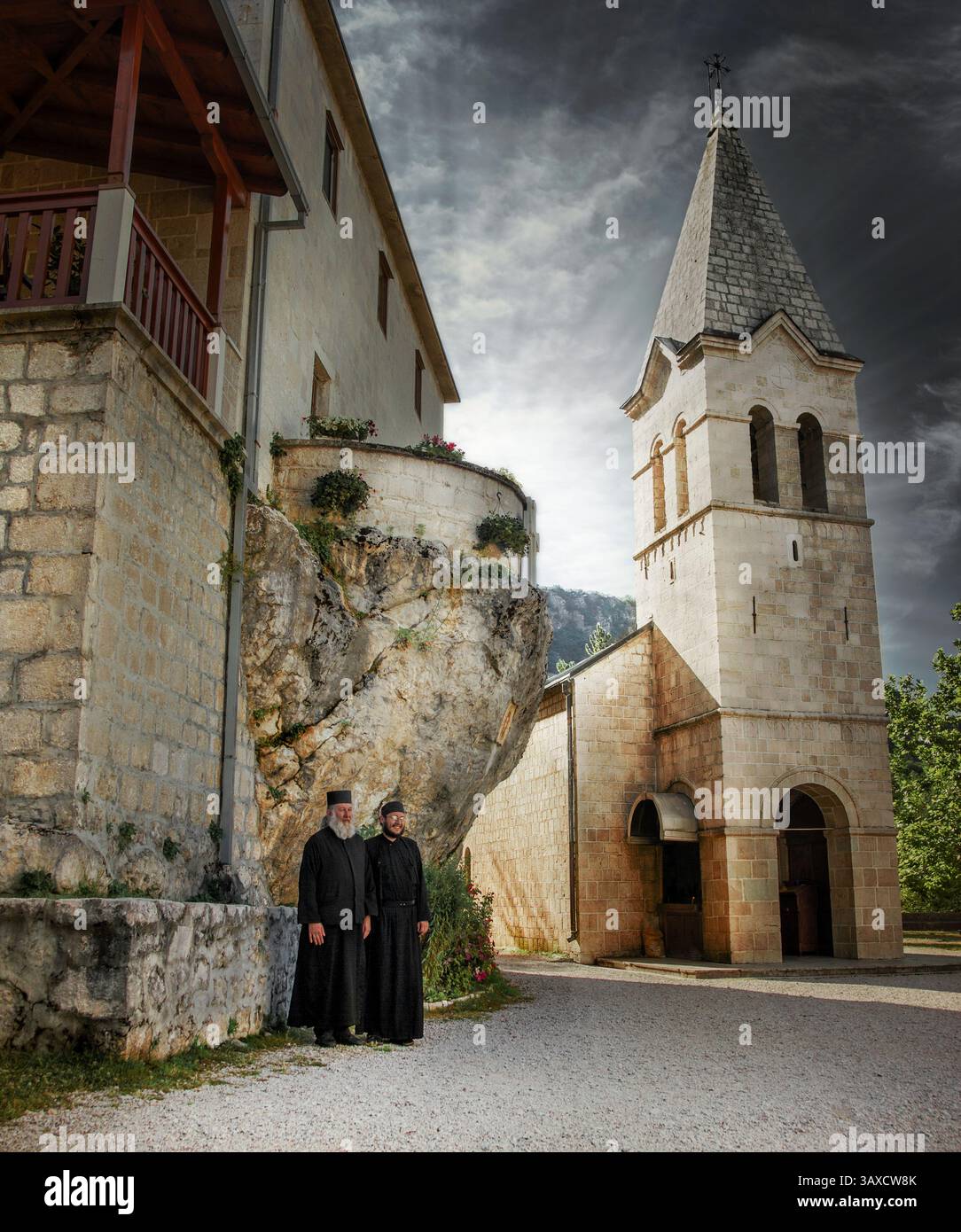 Two monks stand in front of the church Stock Photo - Alamy