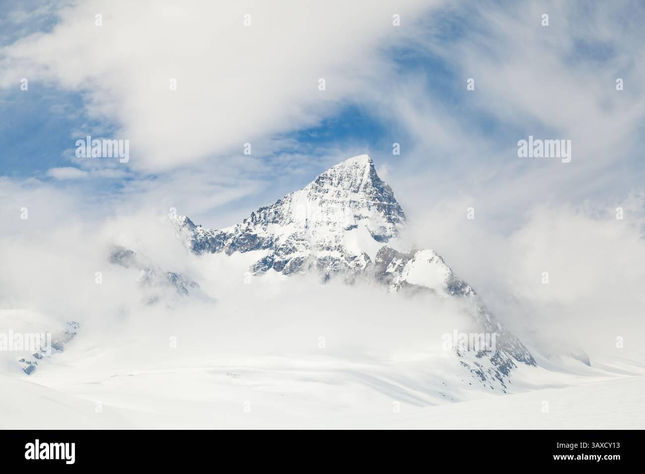 Jagged mountain peak with valley glacier and swirling clouds Stock ...