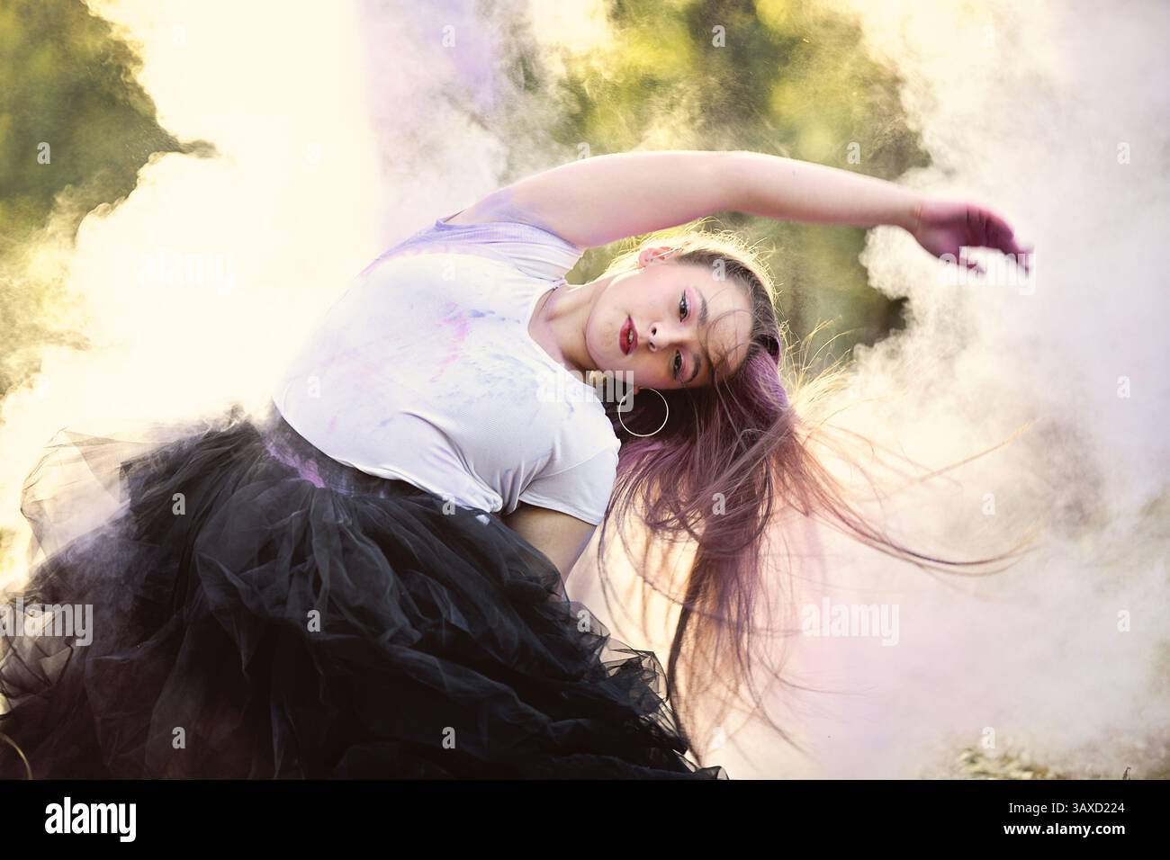 Woman in dynamic dance pose surrounded by pastel powder smoke Stock ...