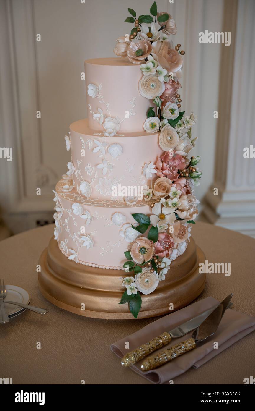 Three-tier blush floral cake with gold base Stock Photo - Alamy