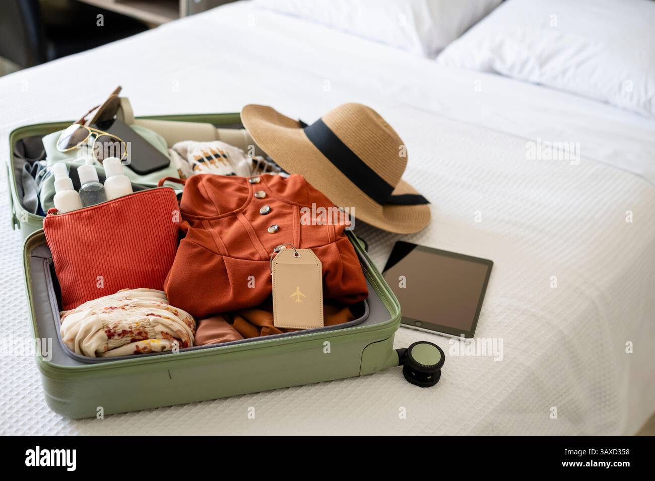 Suitcase packed for spring break on bed Stock Photo - Alamy