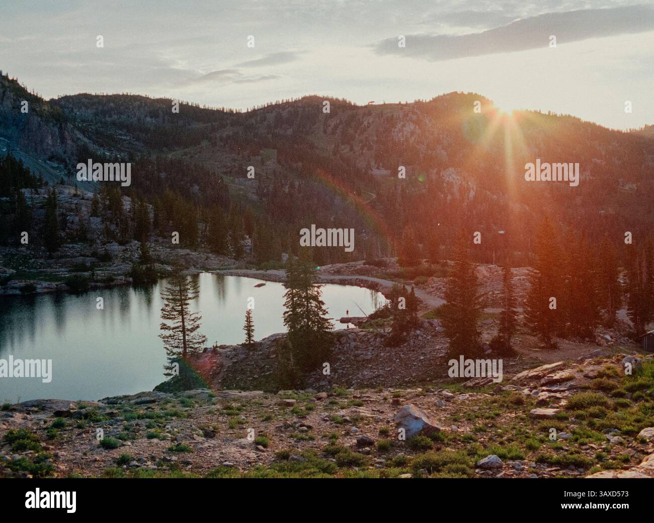 Sunrise cuts across a wild backcountry basin with alpine water Stock Photo - Alamy
