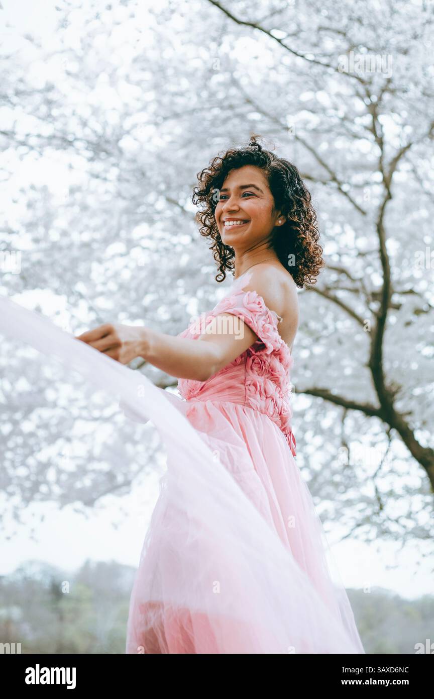 A woman twirling in a long pink dress Stock Photo - Alamy