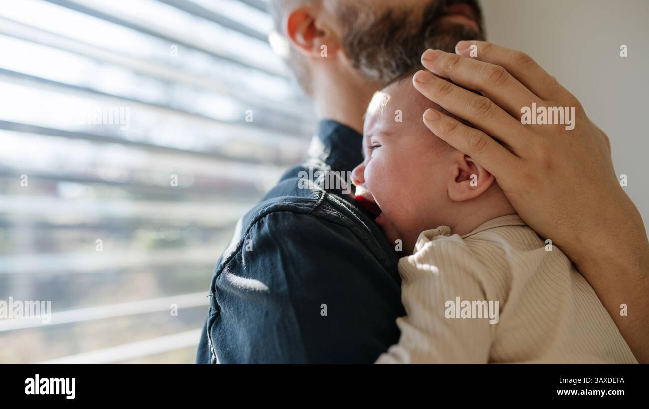 Father comforting his crying baby son Stock Photo - Alamy