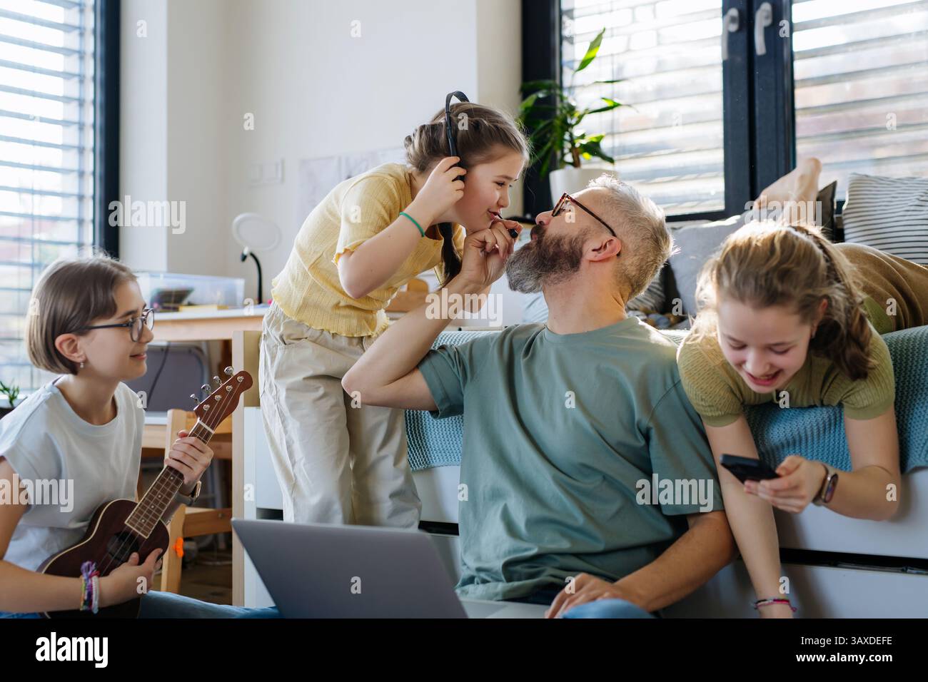 Father with three daughters trying to work from homeoffice Stock Photo ...