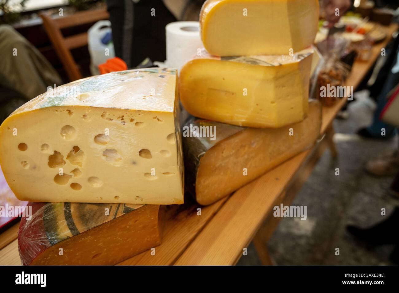 Farm cheese on a market stall, huge wheels of cheese of different types ...