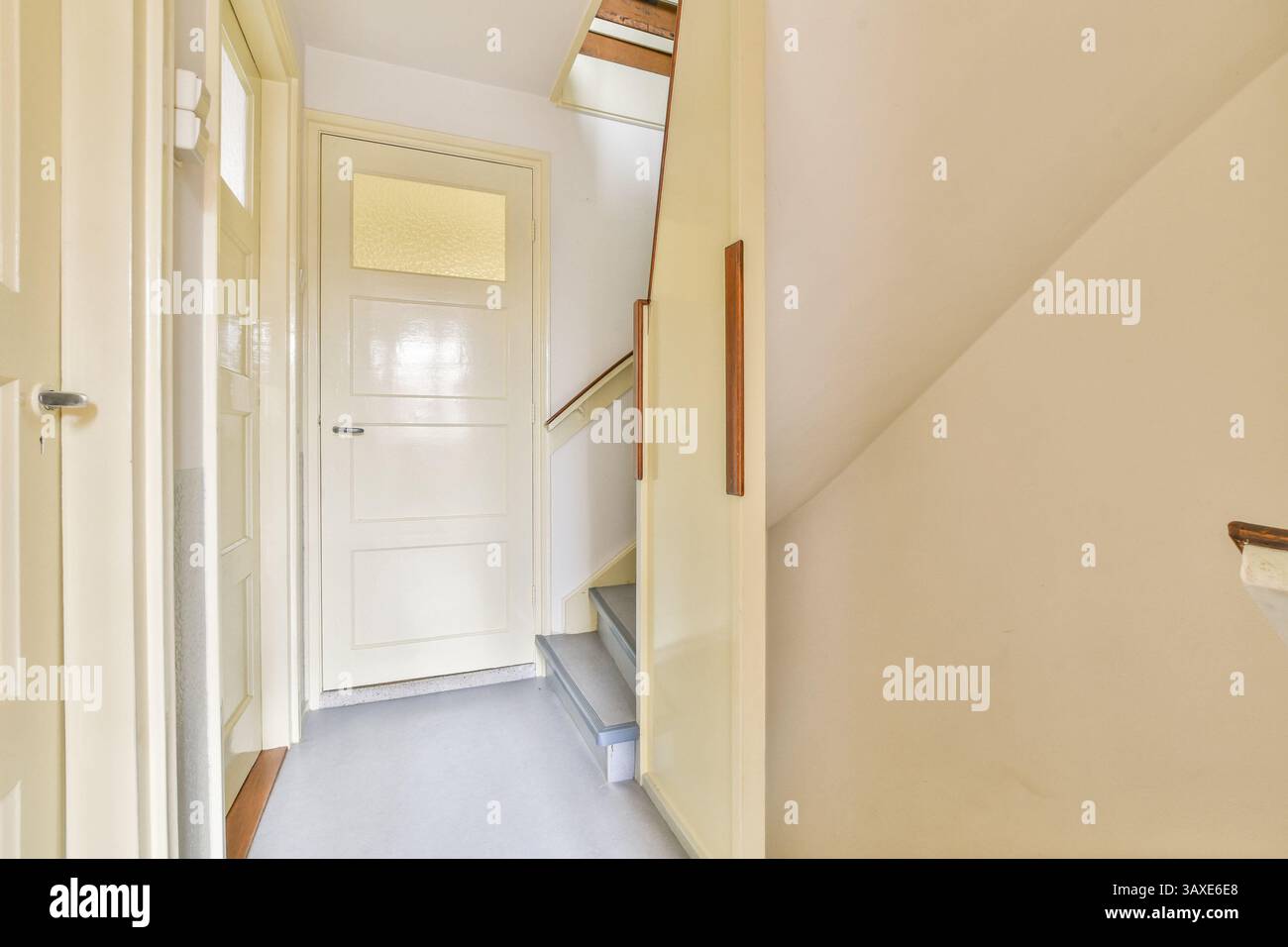 A well-lit interior hallway featuring a staircase, highlighting clean ...