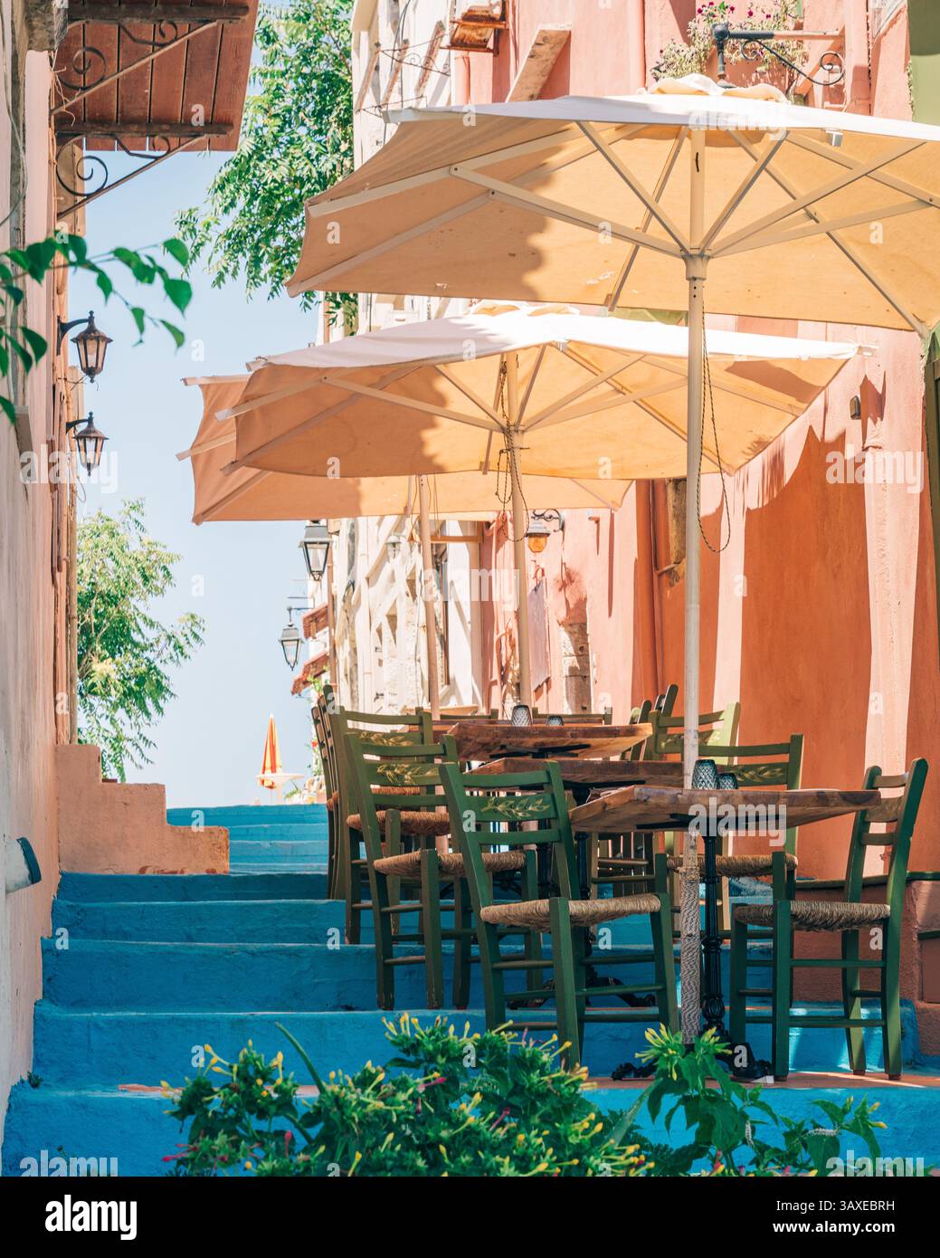 Quaint outdoor café with wooden chairs and parasols along a colorful ...