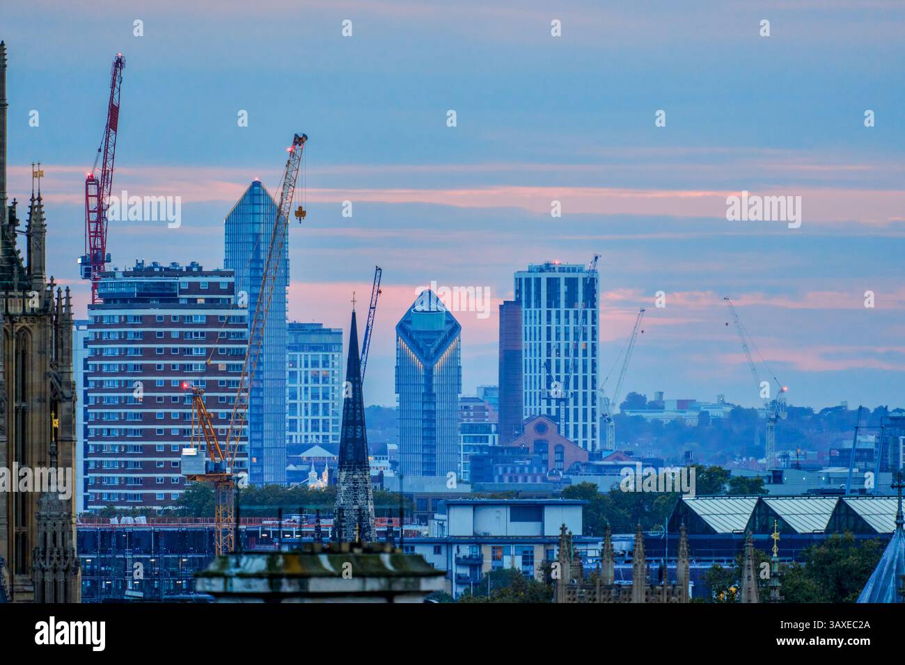 Modern buildings and construction cranes in the London skyline at dusk ...