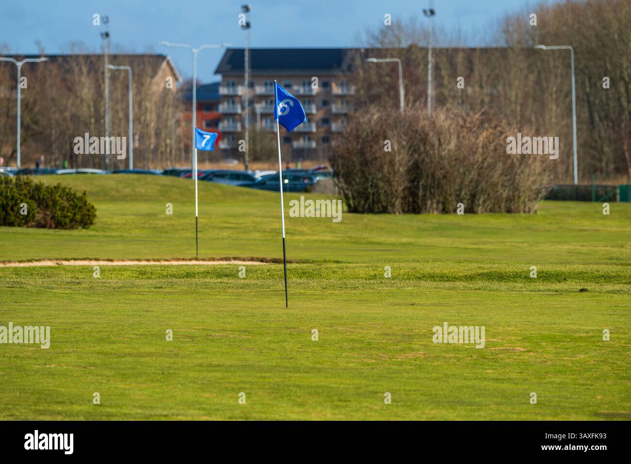 Golf flags on course with urban backdrop Stock Photo - Alamy