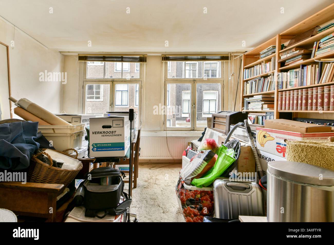 A disorganized room filled with various items like boxes, a wicker ...