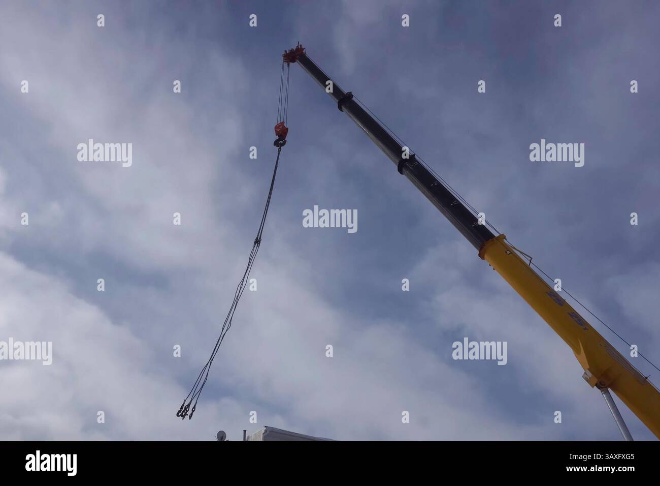 Crane boom with hook. Lifting and moving equipment Stock Photo - Alamy
