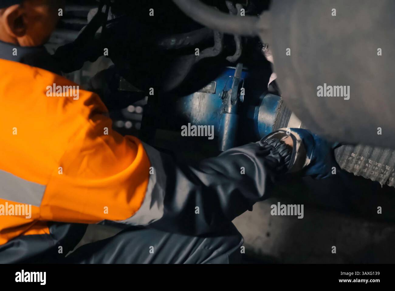 Installation of the drain hose to the road tanker Stock Photo - Alamy