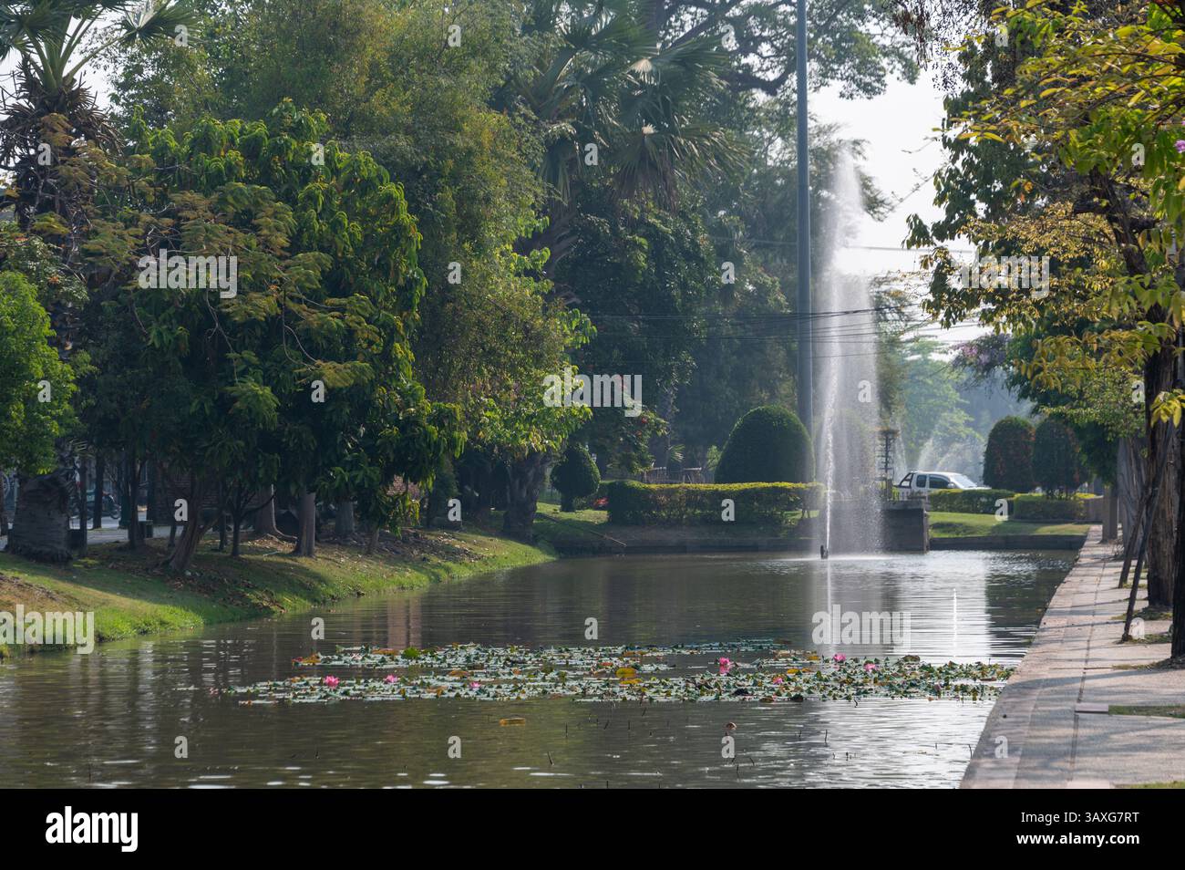 A water fountain in the middle of the wide moat that surrounds the old ...