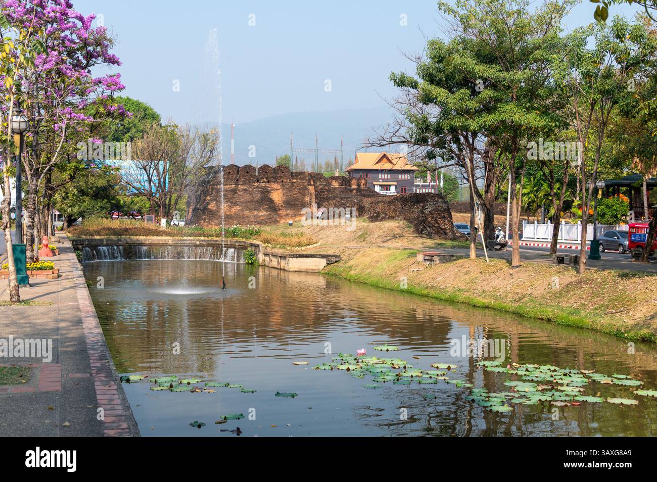 A water fountain in the middle of the wide moat that surrounds the old ...