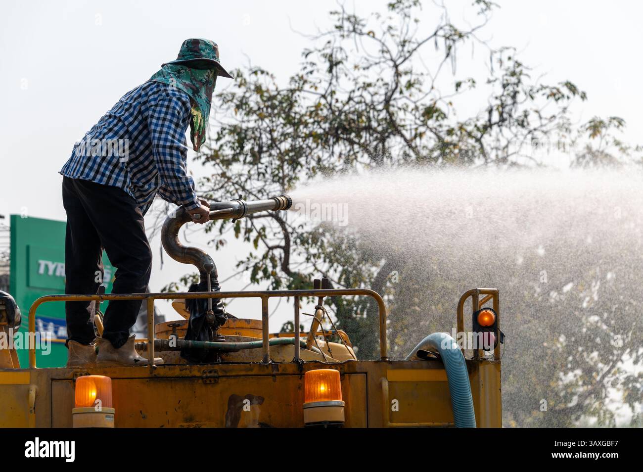 A local parks employee using a water pressure jet hose from a mobile ...