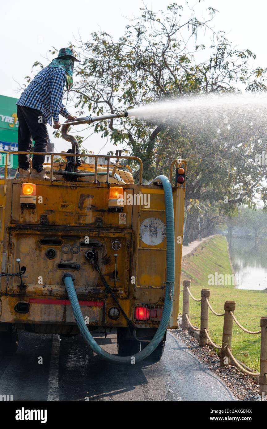 A local parks employee using a water pressure jet hose from a mobile ...