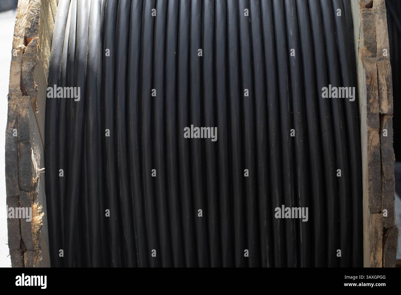 Close up showing black industrial electric cables wound on a wooden ...