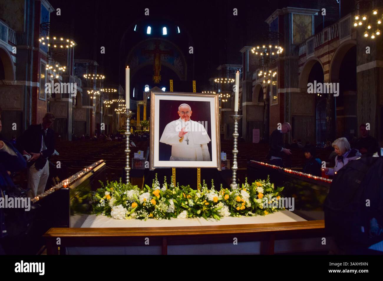London, UK. 21st April 2025. People light candles next to a picture of ...