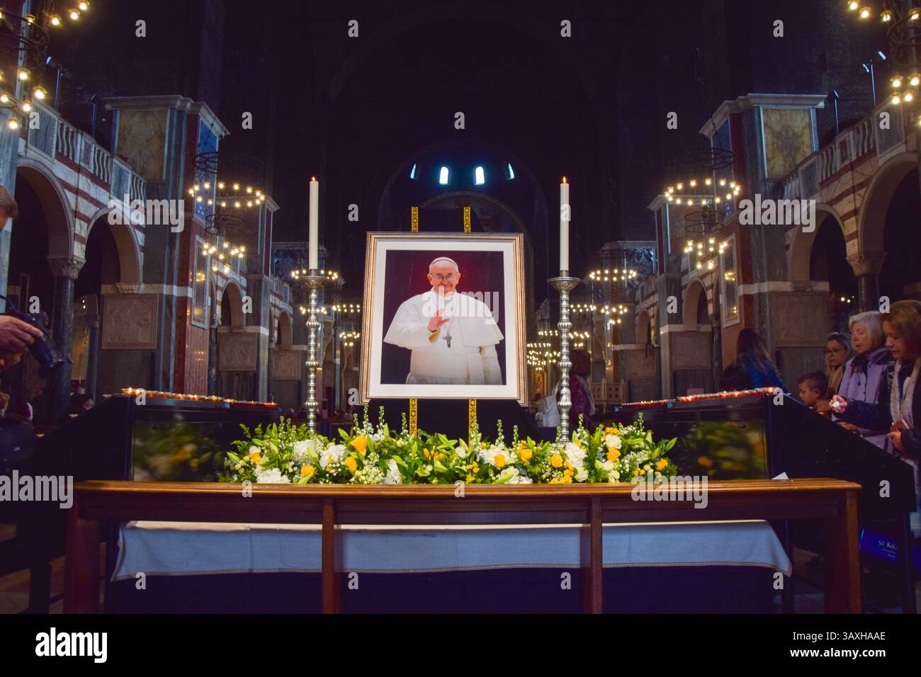 London, UK. 21st April 2025. People light candles next to a picture of ...