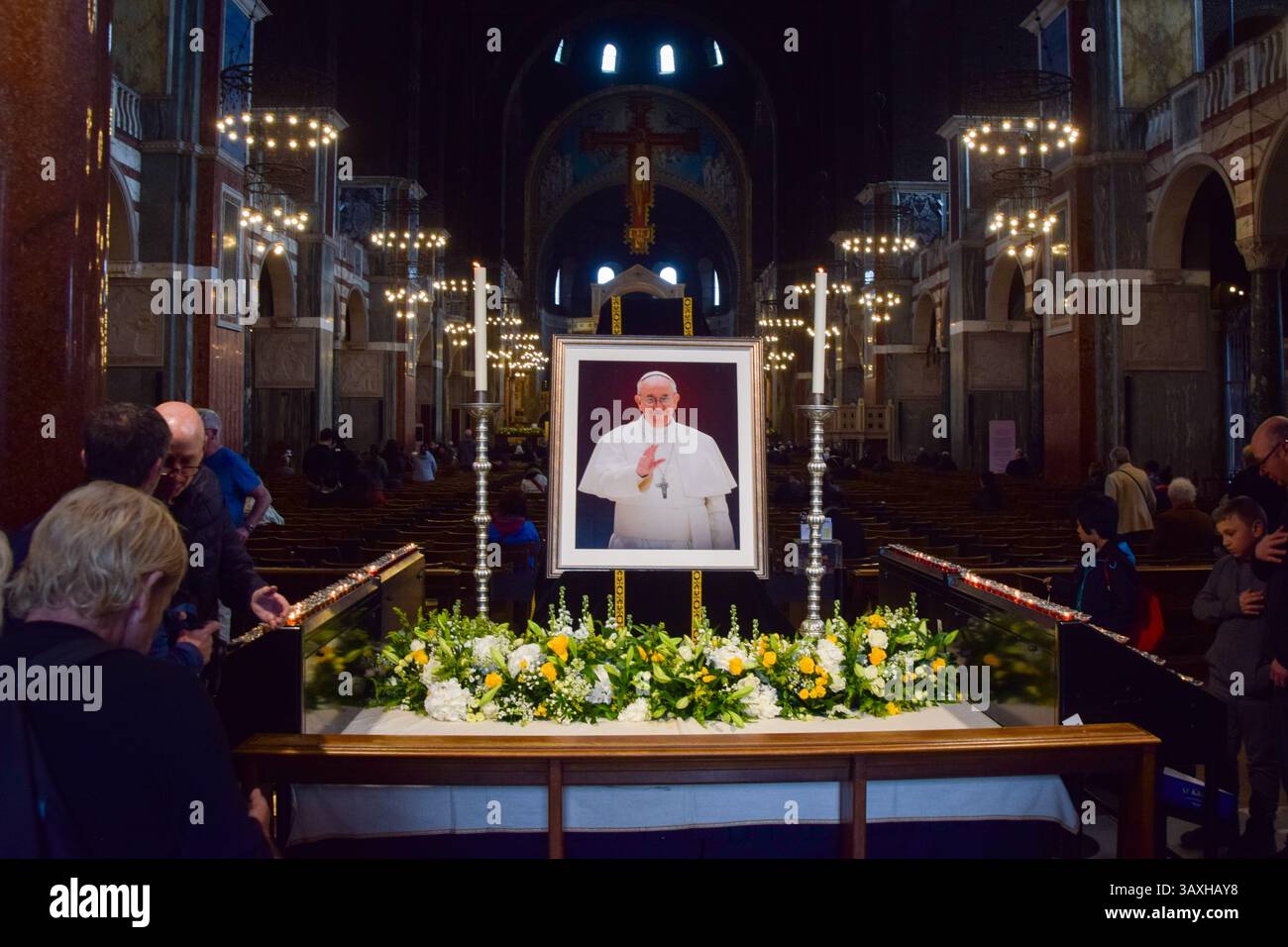London, UK. 21st April 2025. People light candles next to a picture of ...