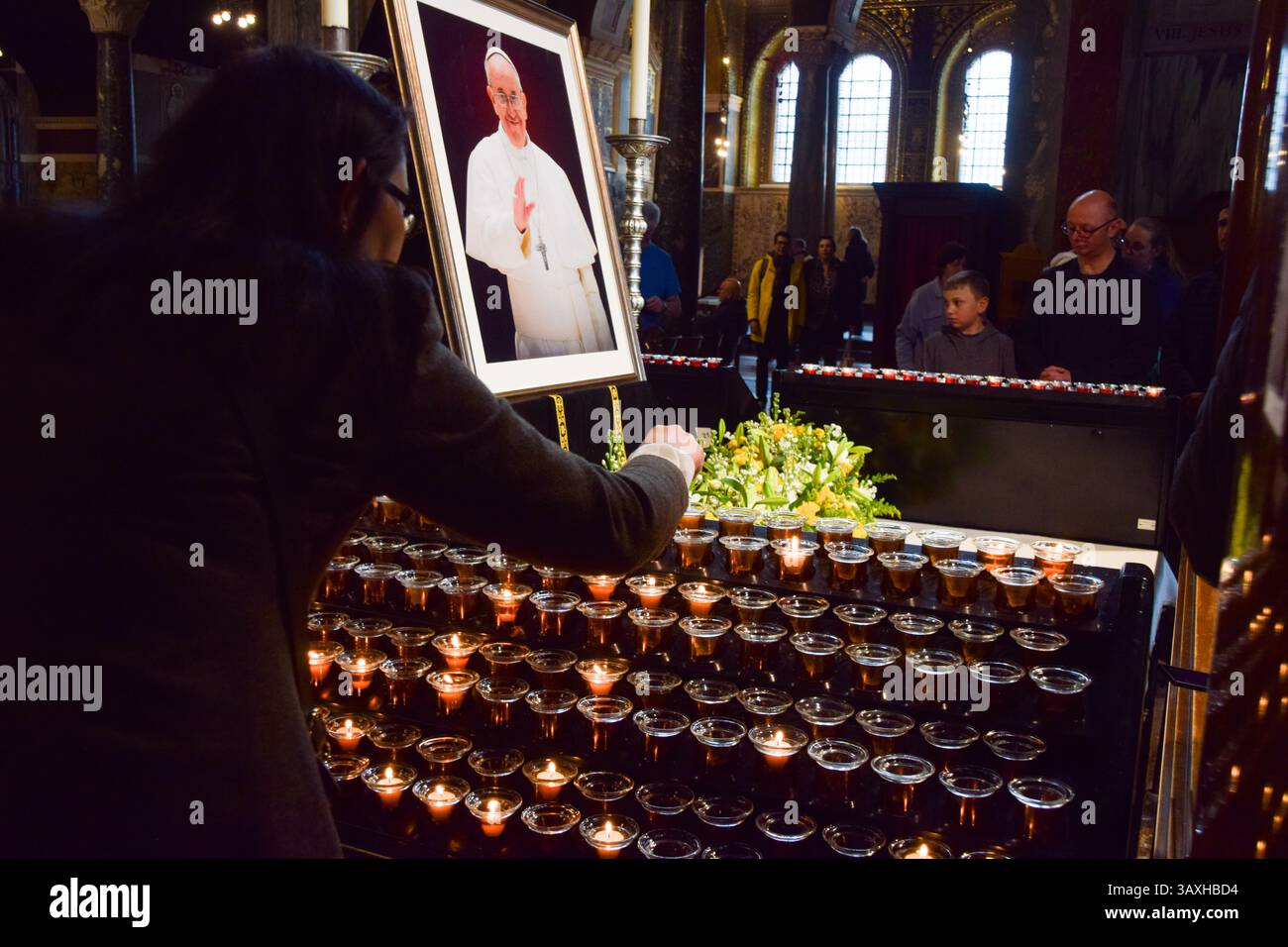 London, UK. 21st April 2025. People light candles next to a picture of ...