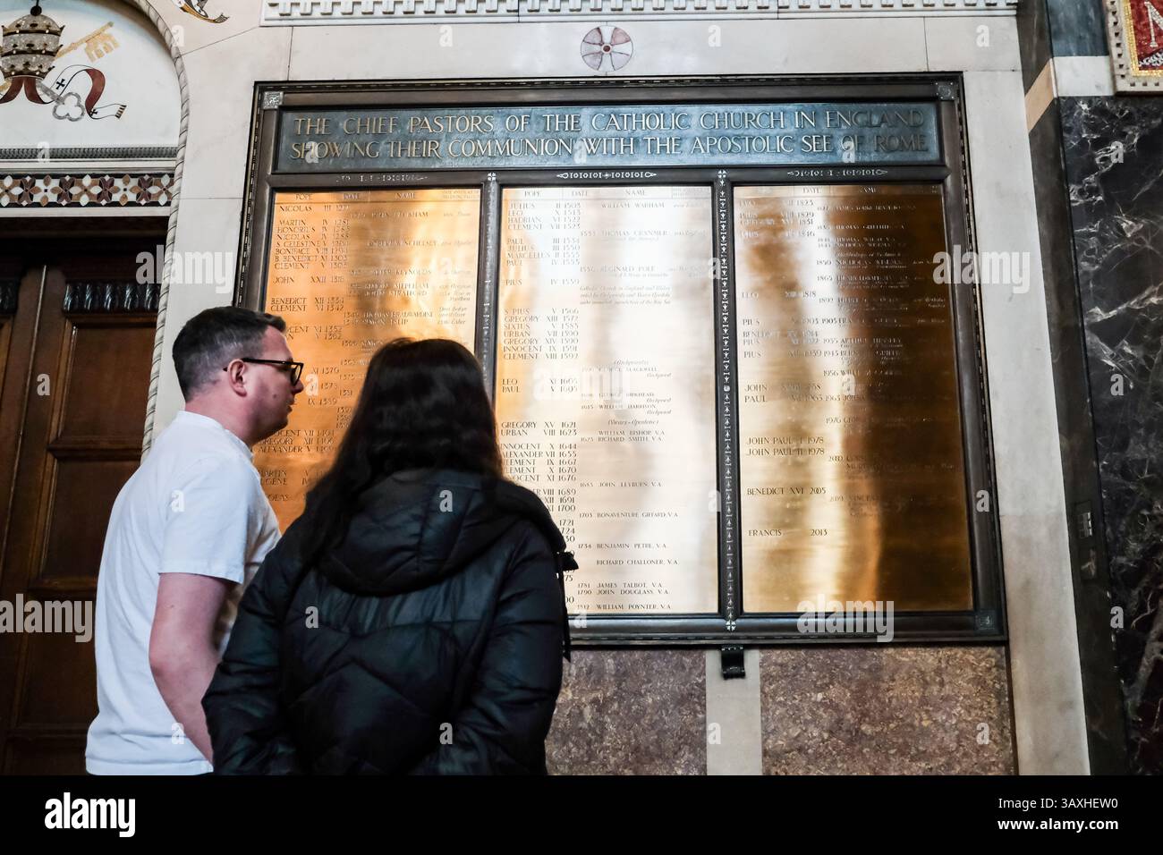 London, UK. 21st April, 2025. People read the names of popes and the ...