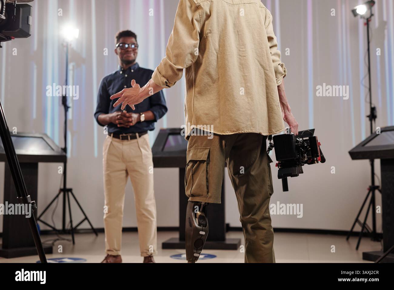 Disabled man with camera explaining something to African guy during ...