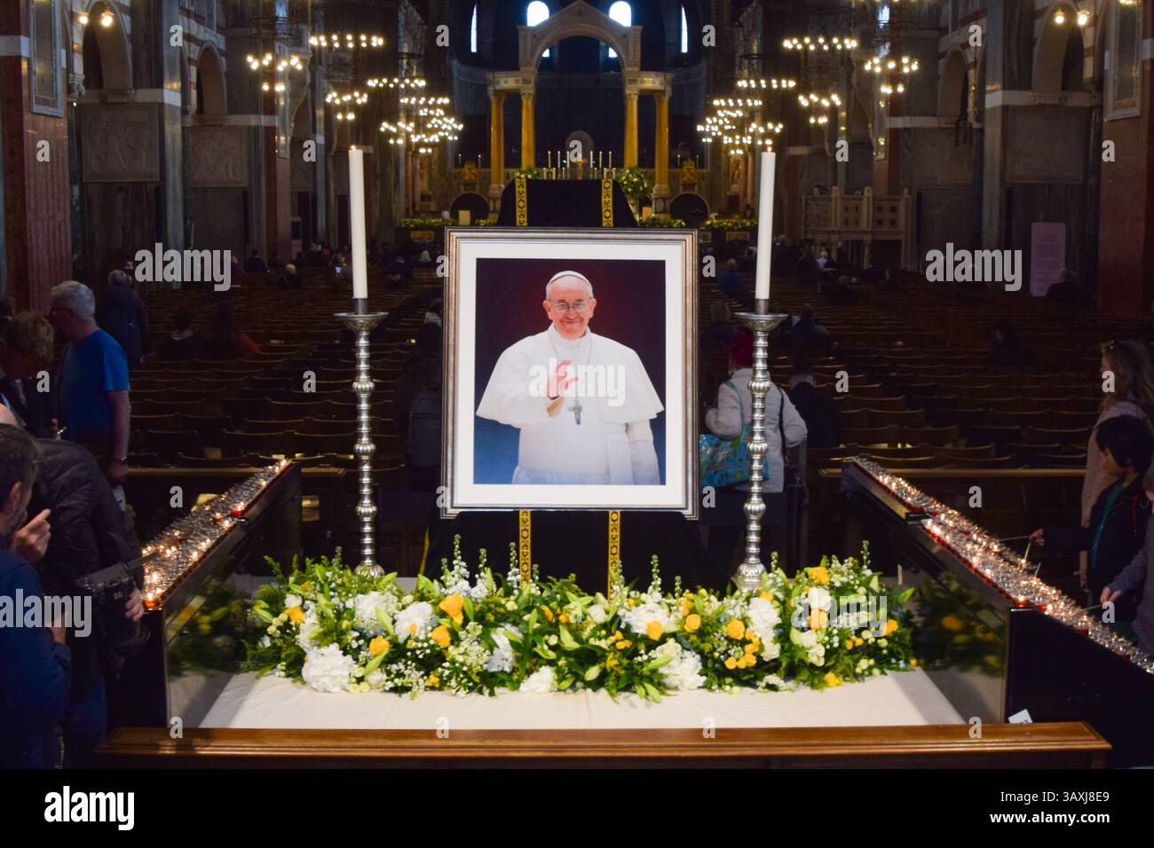 London, UK. 21st April 2025. People light candles next to a picture of ...