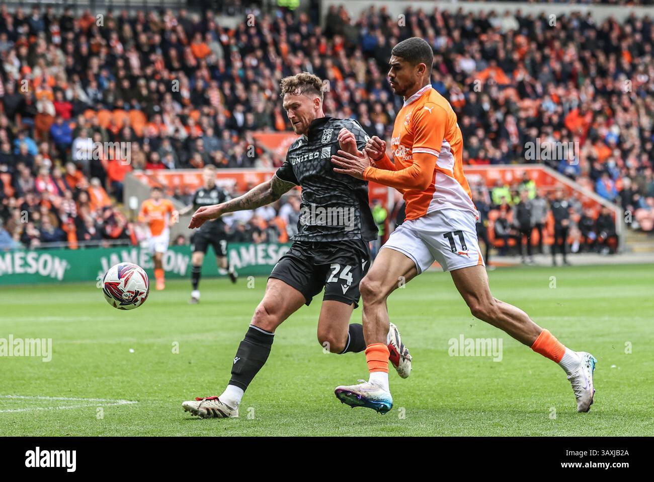 Dan Scarr of Wrexham holds off Ashley Fletcher of Blackpool during the ...