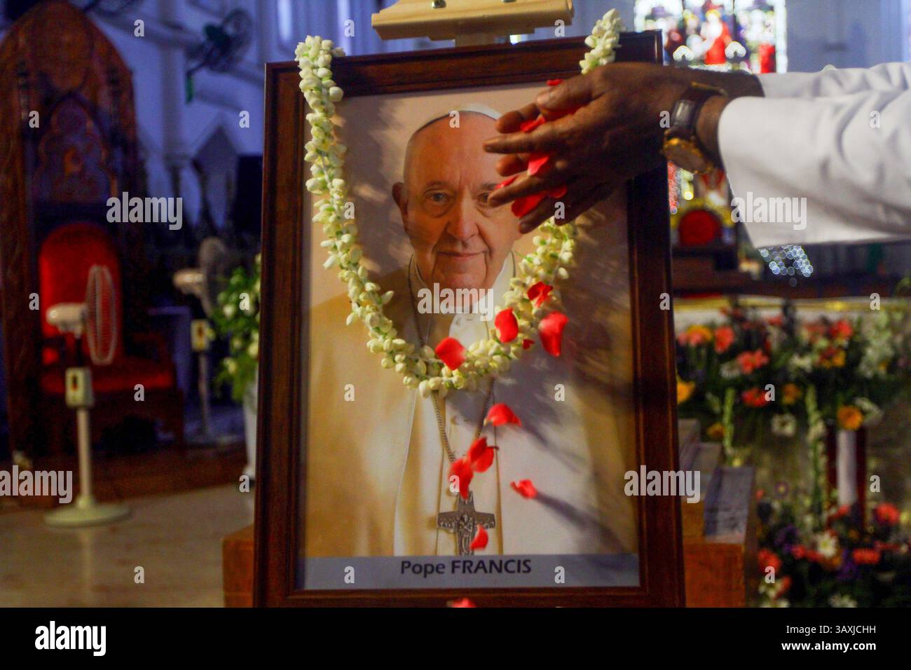 Religion & Belief People pray in front of a portrait of Pope Francis at ...