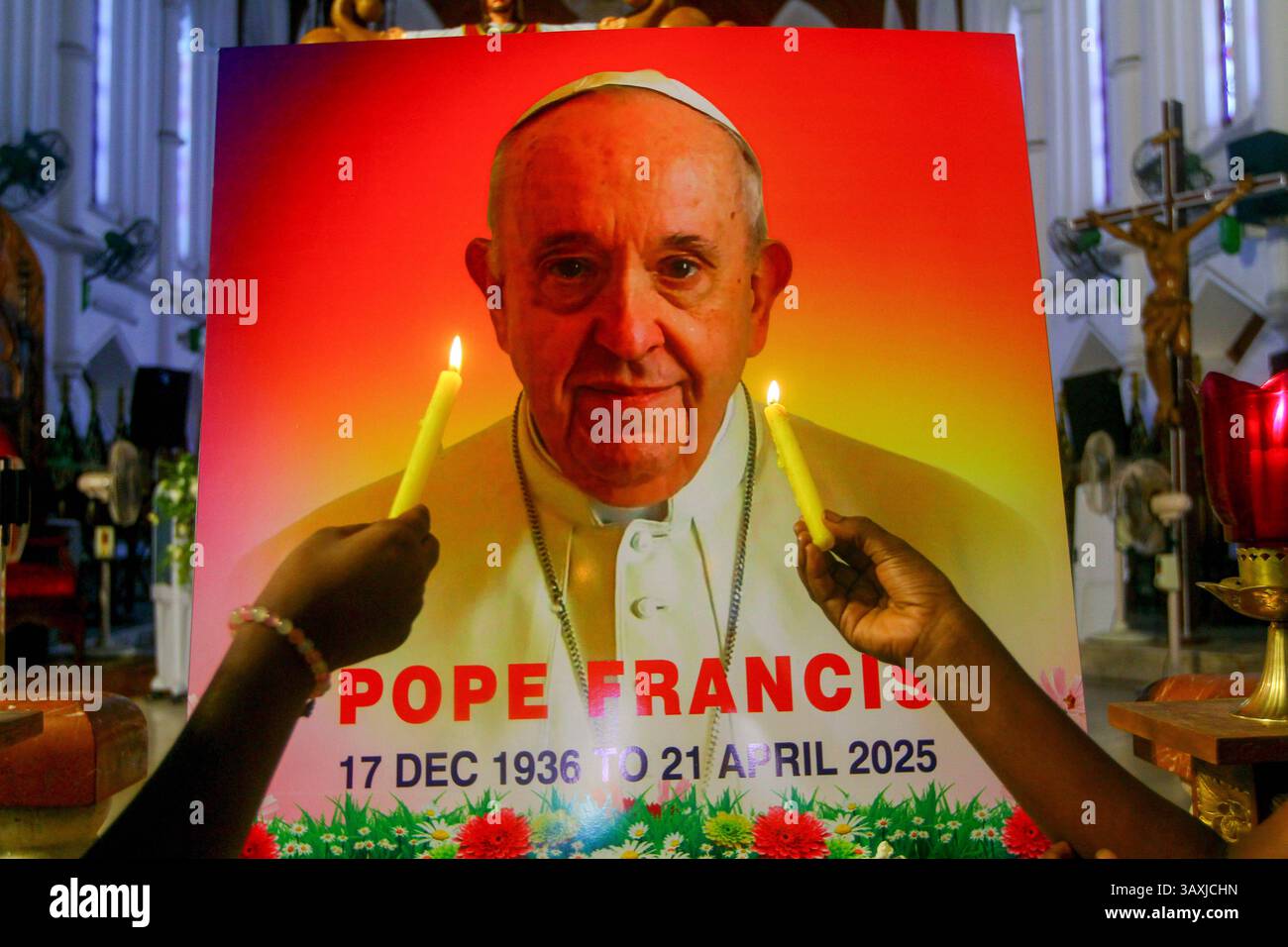 Religion & Belief People pray in front of a portrait of Pope Francis at ...
