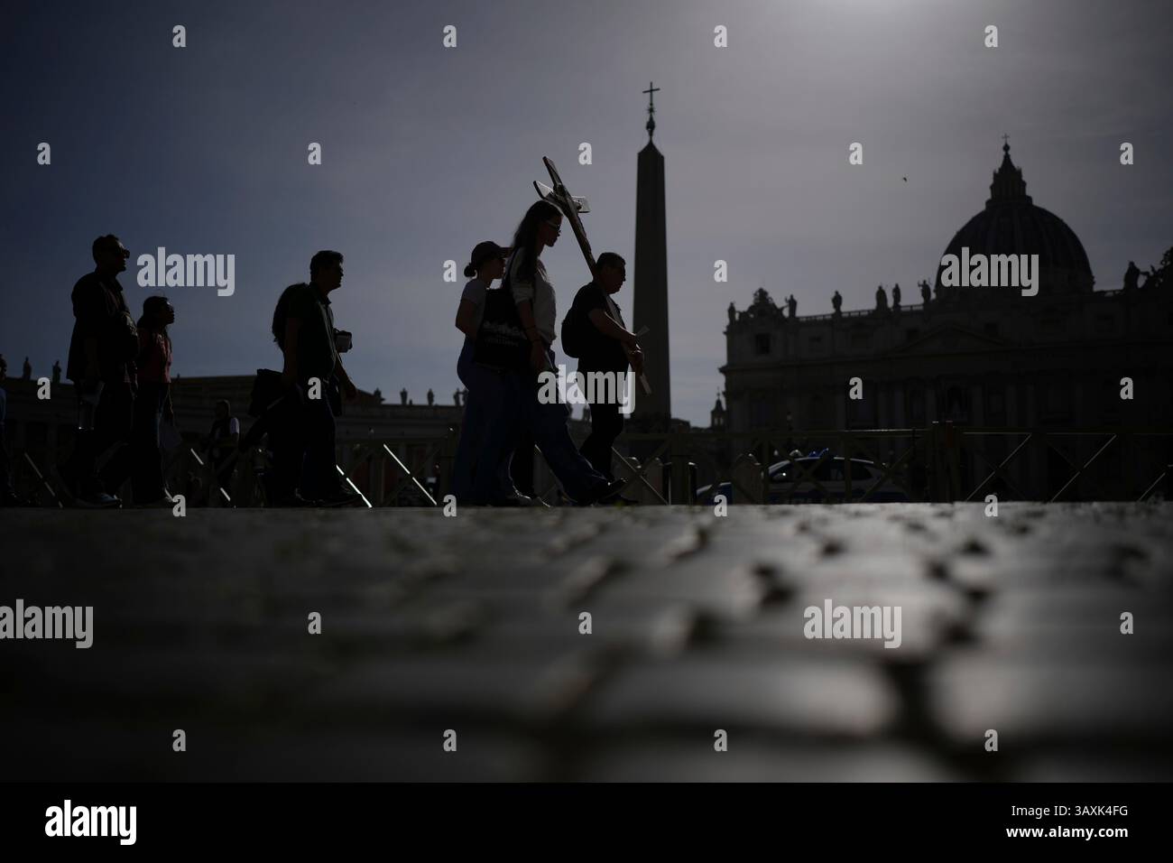 A man carries a cross in St. Peter's Square at the Vatican after ...