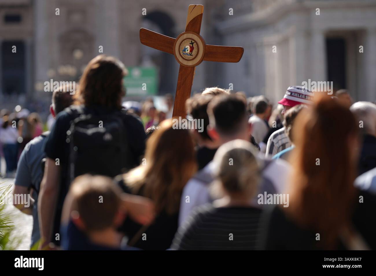 Pilgrims carrying a cross make their way to the Holy Door in St. Peter ...